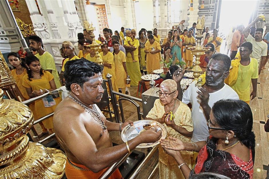Couple with baby among temple devotees | The Star